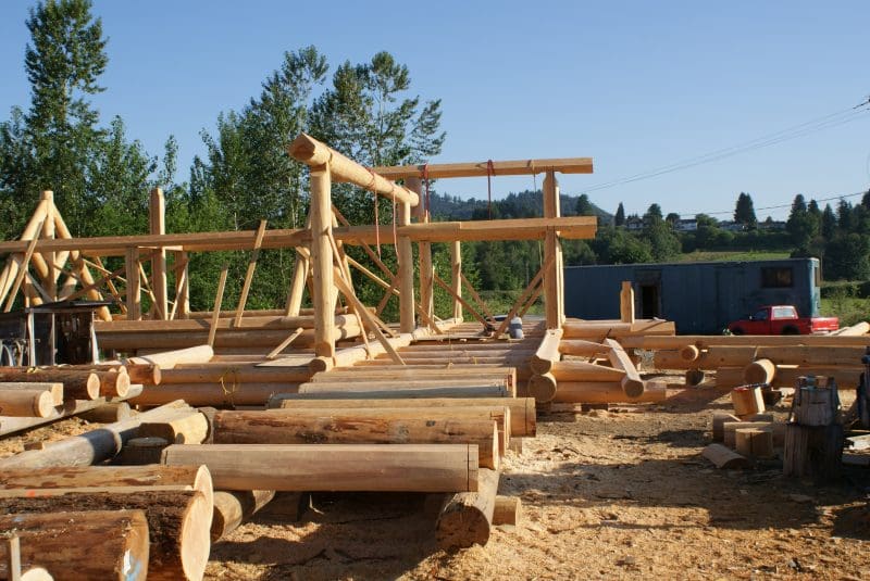 Why are log homes built in a log yard?